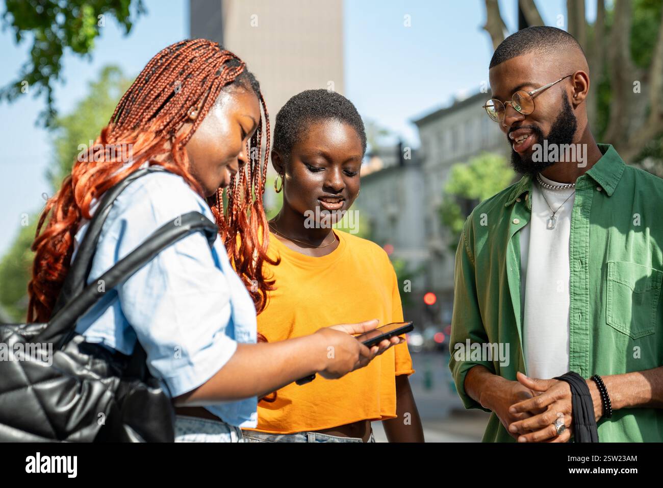 Happy group of african friends chatting, woman with phone showing ...
