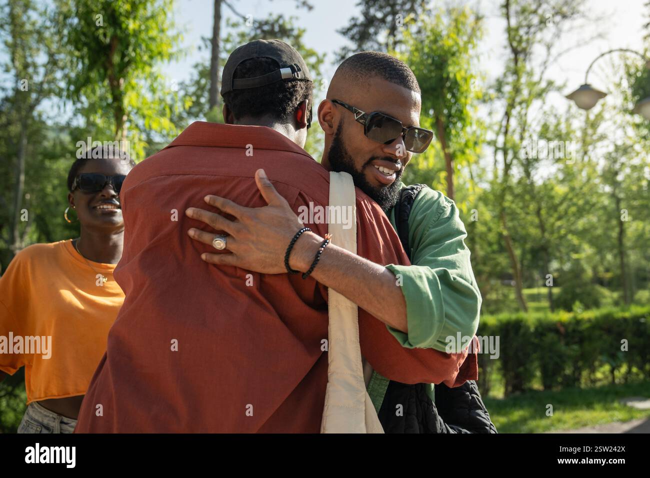 Cheerful African American guys friends hugging on street outside ...