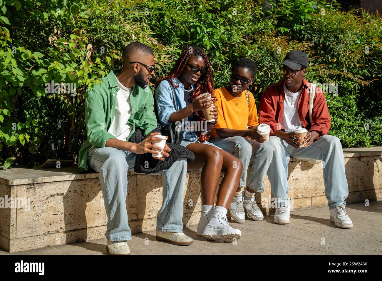 Calm contented black students, men, women, resting outside together ...