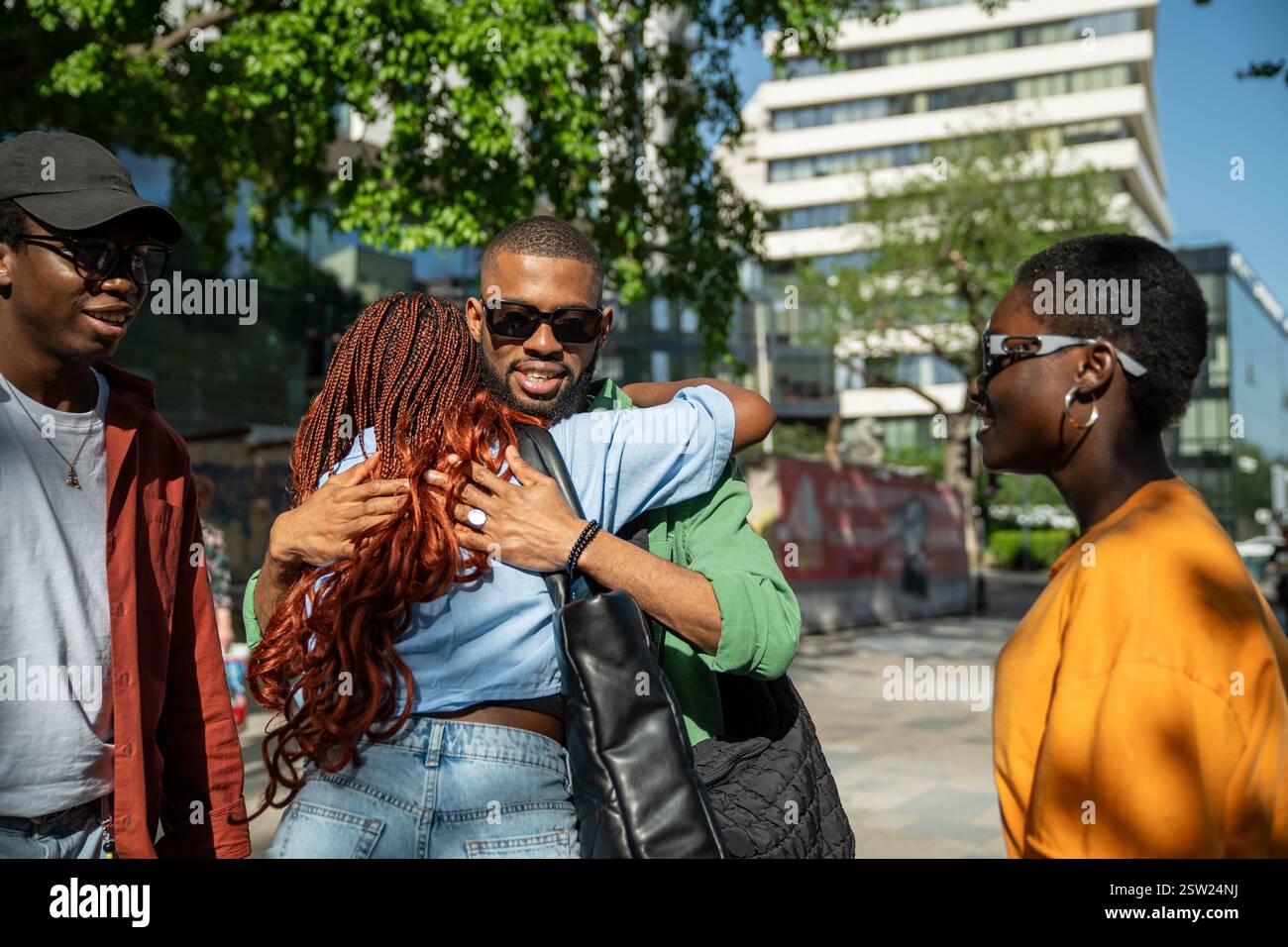 Joyful contented african american friends students hug meeting outside ...