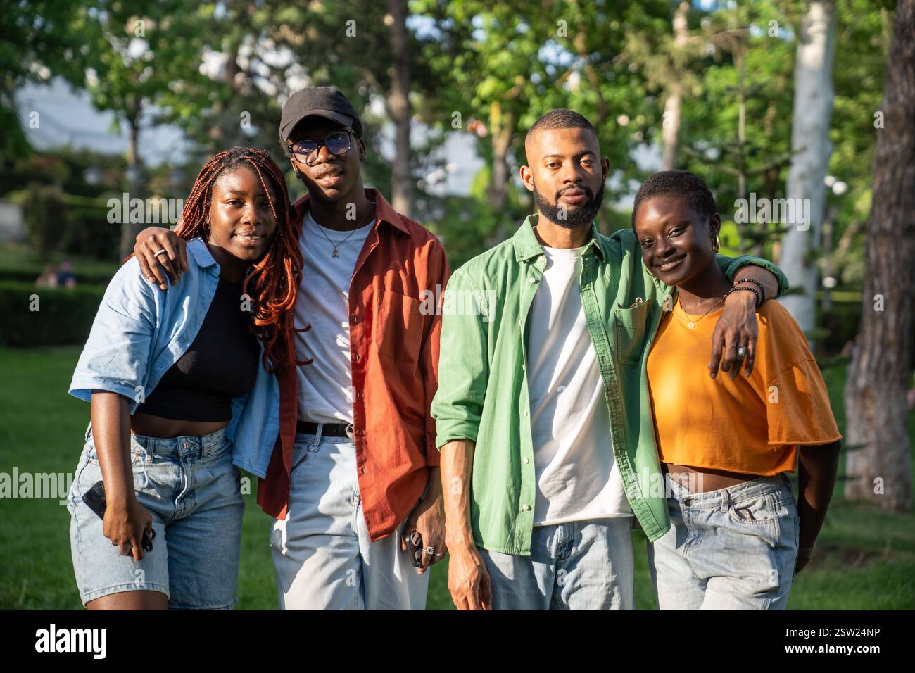 Two African American student couples in love stand in park while ...