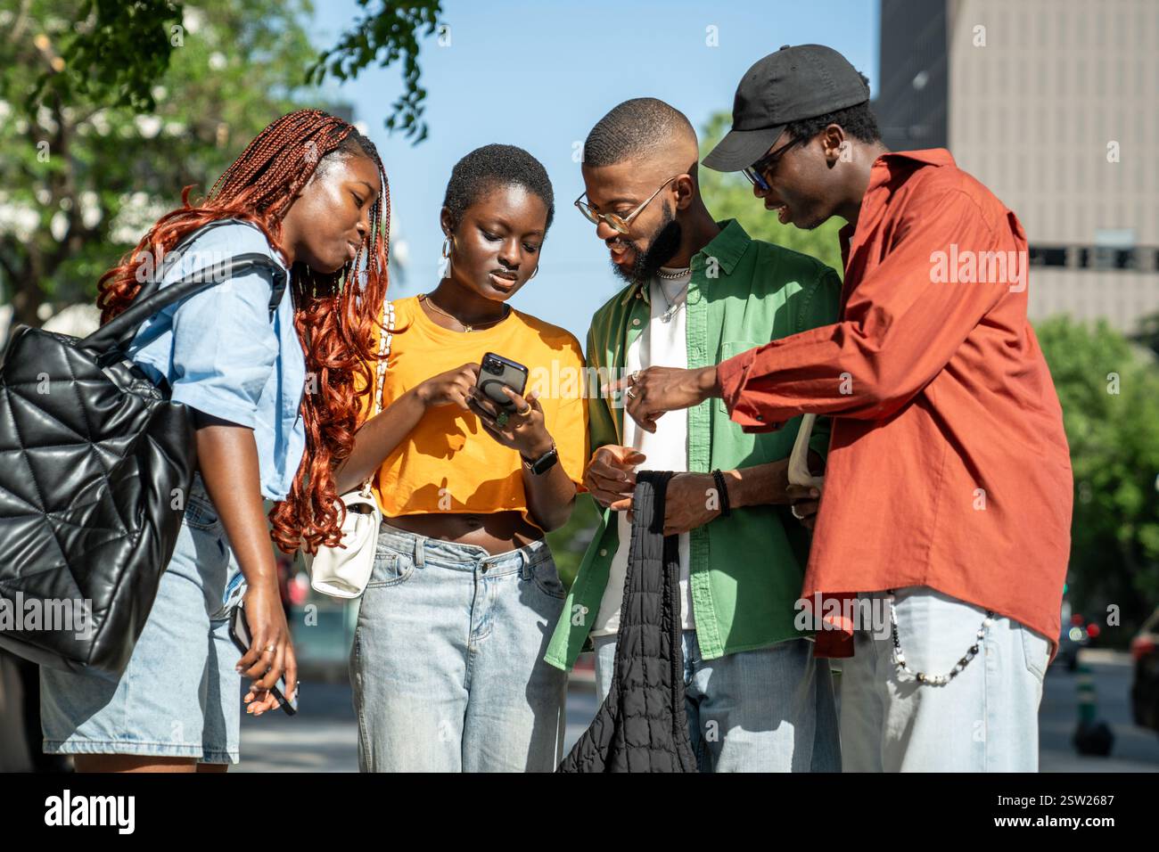Group of buddies students looking at phone screen with interest ...