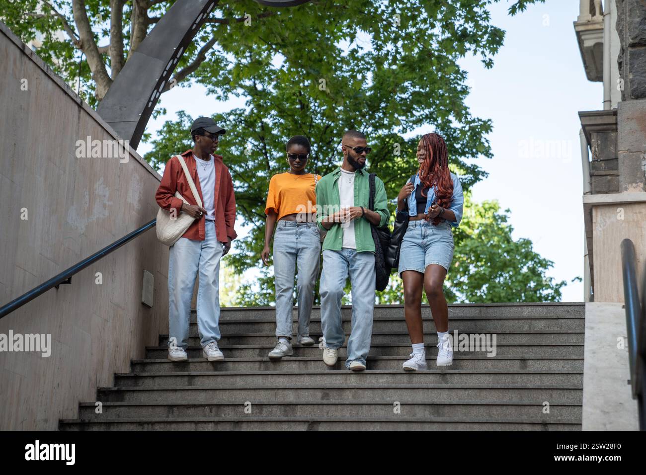 Group of thoughtful African American friends enthusiastically discuss ...
