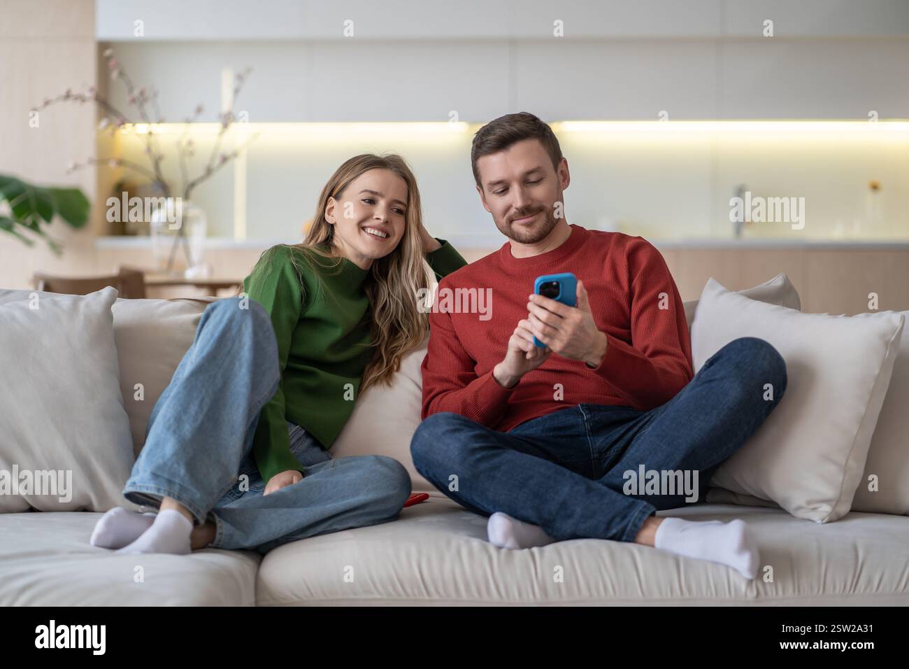 Happy relaxed married couple spends time together on home couch smiling ...