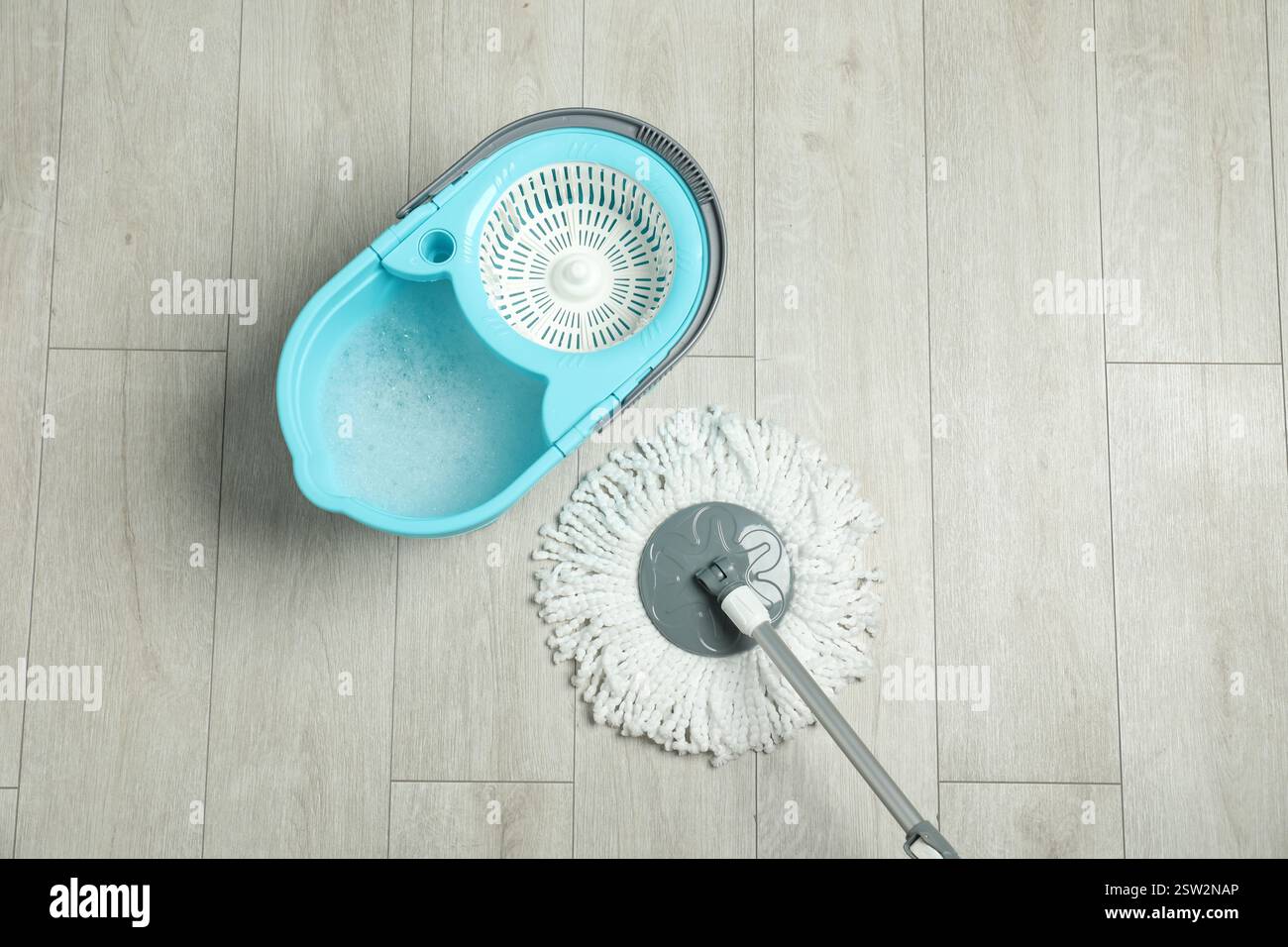String mop and bucket with detergent on wooden floor, top view Stock ...