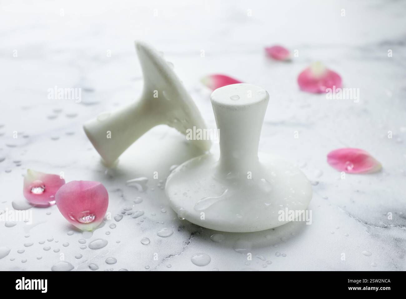 Wet spa stones and petals on white marble table, closeup Stock Photo ...