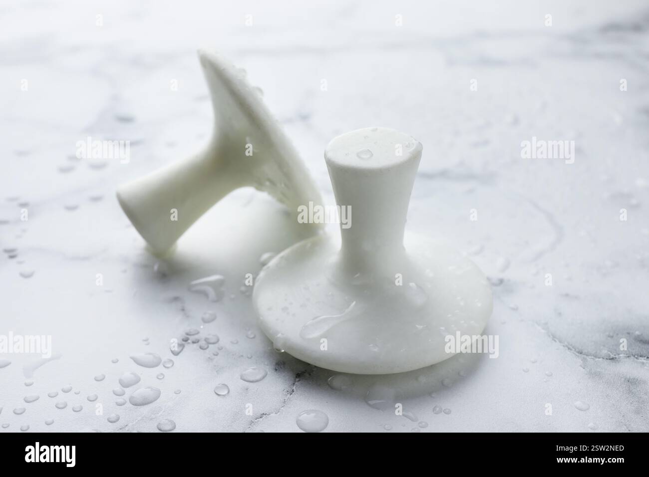 Wet spa stones on white marble table, closeup Stock Photo - Alamy