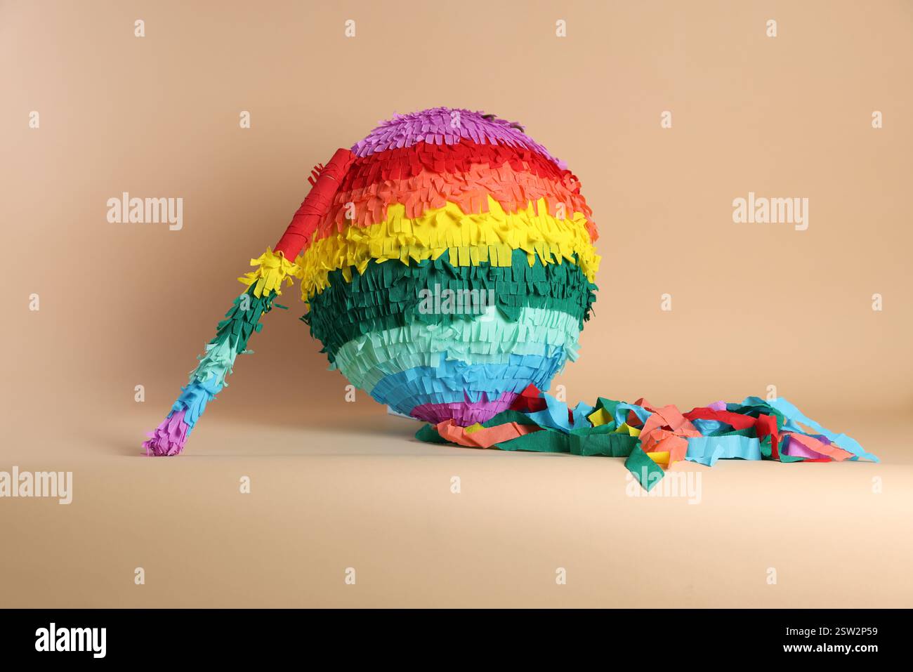 Colorful pinata and stick on beige background Stock Photo - Alamy