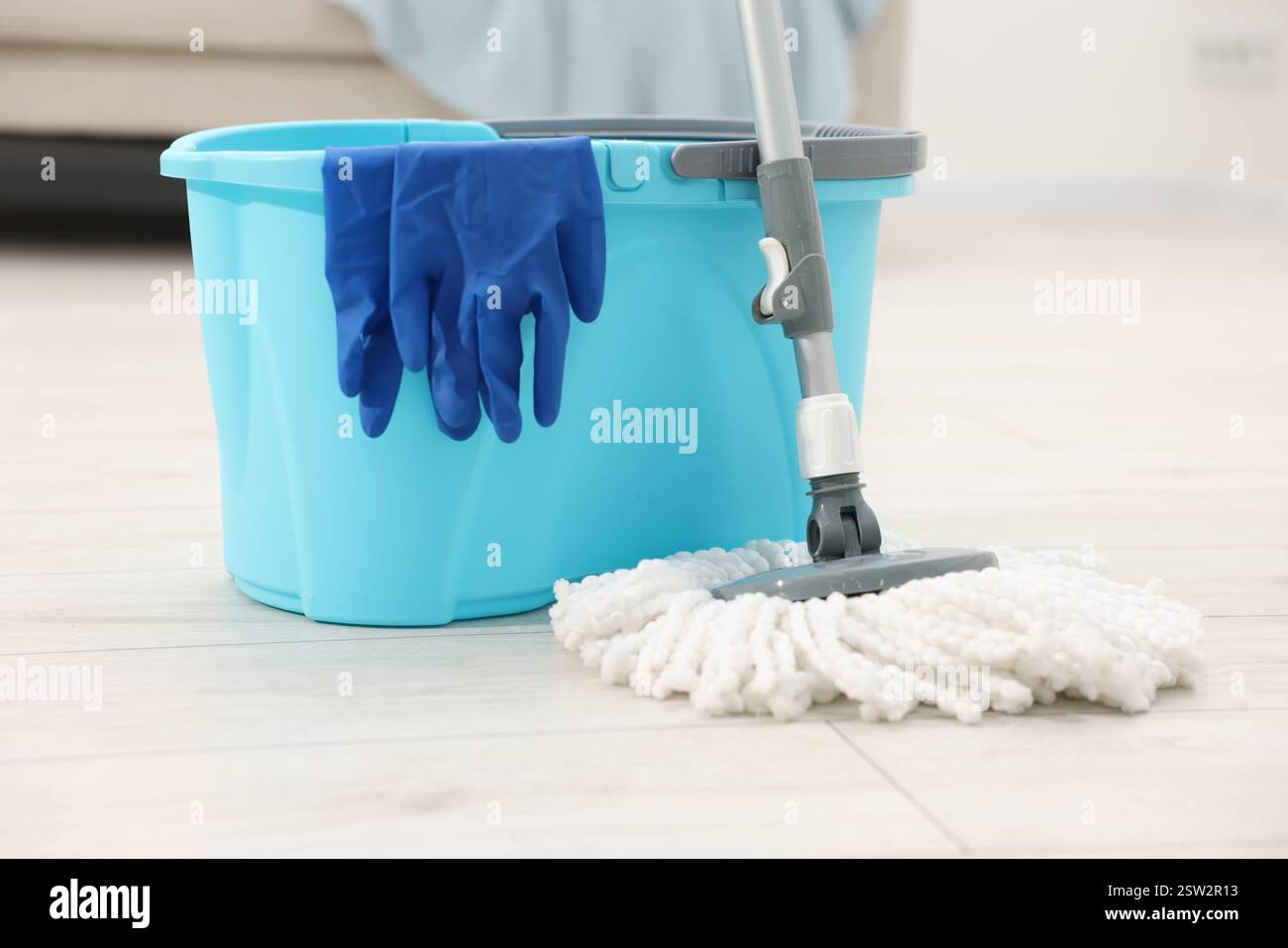 String mop, bucket and gloves on floor indoors Stock Photo - Alamy