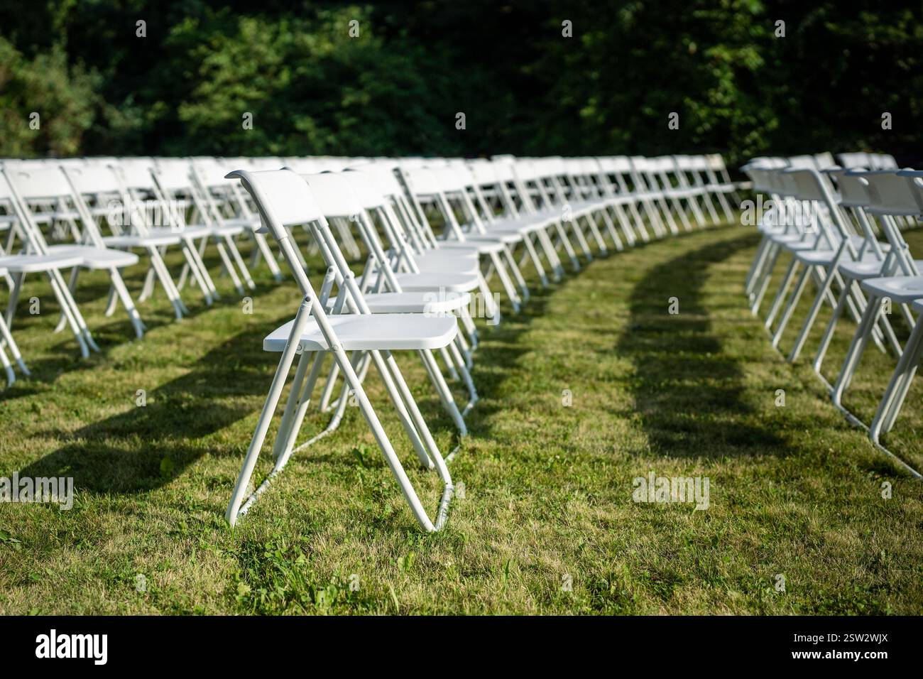 Empty folding chairs stand in rows on green grass hi-res stock ...