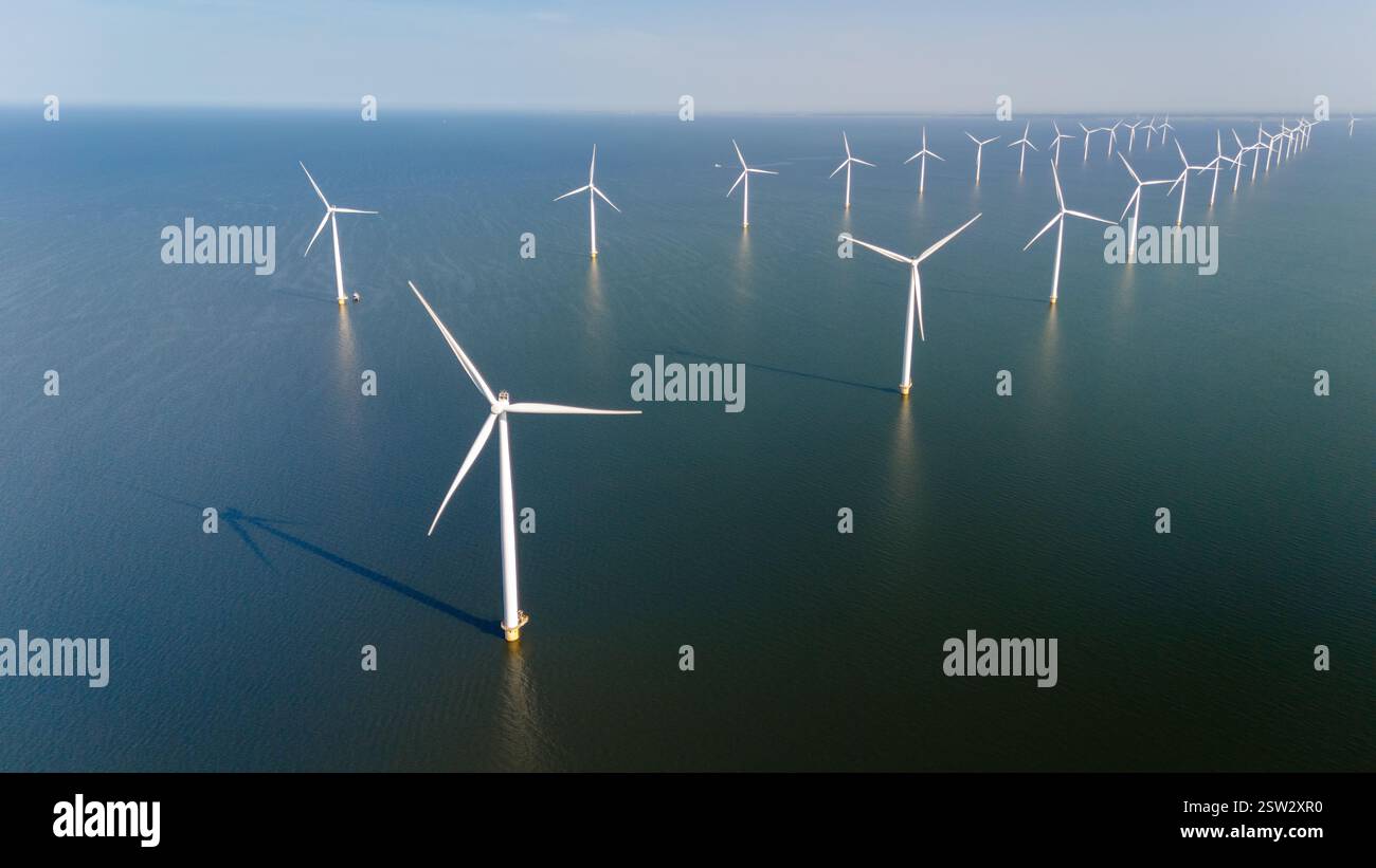 Tall wind turbines gracefully rise from the sea hi-res stock ...
