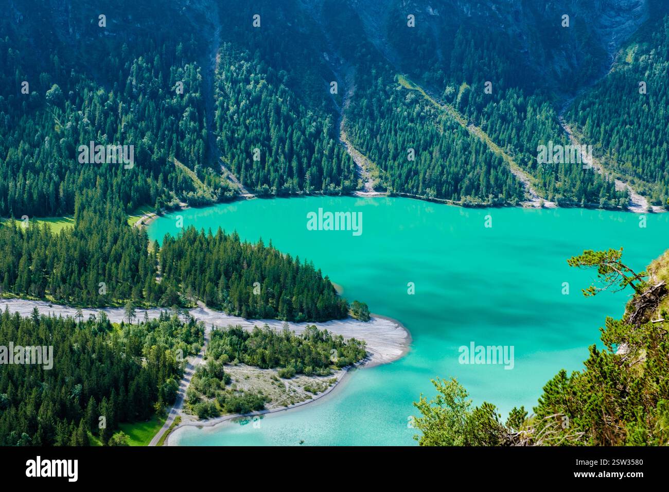 The turquoise waters of Plansee gleam under the summer sun, surrounded ...