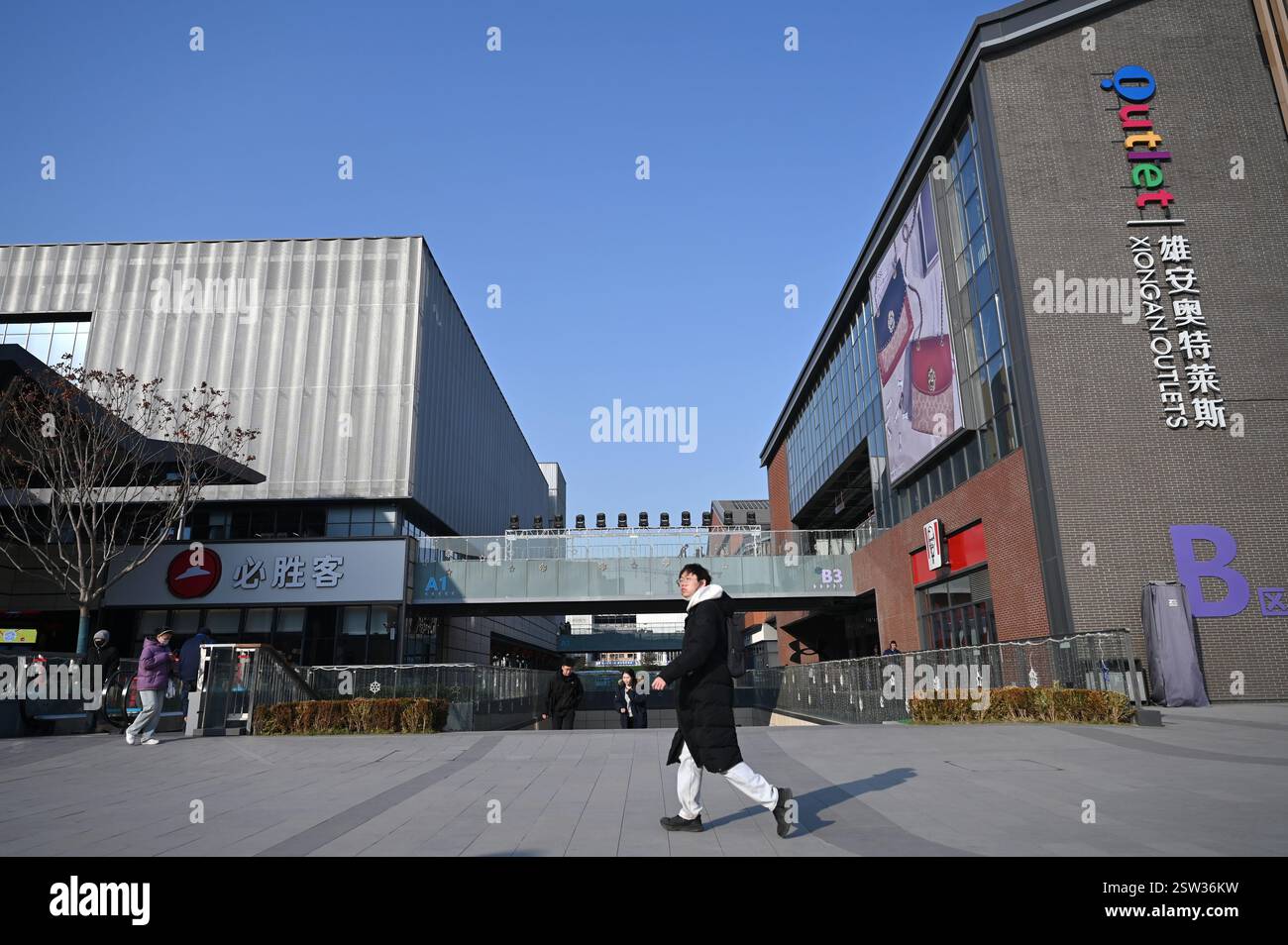 PRODUCTION - 12 January 2025, China, Xiong'an: A man walks past a ...