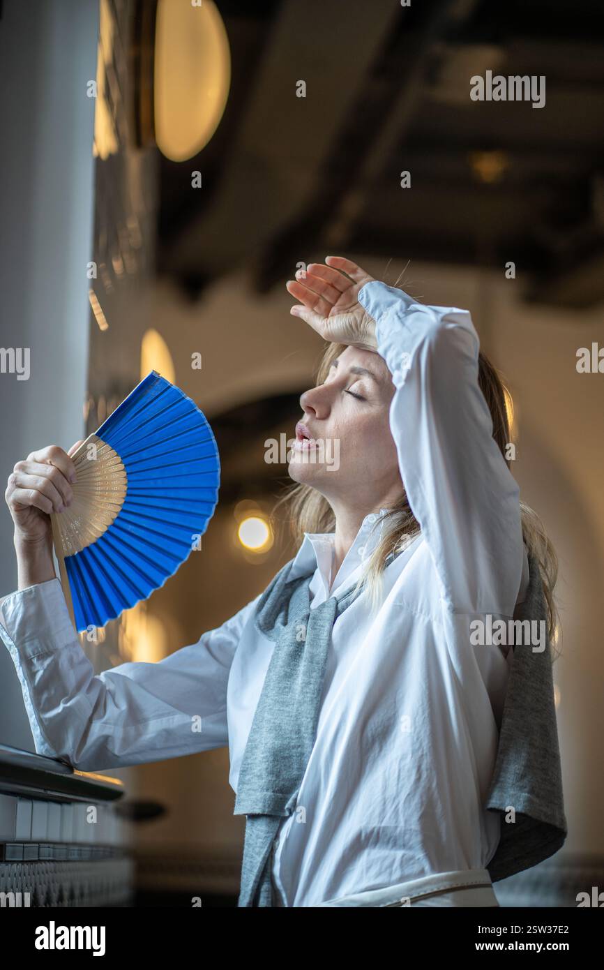 Woman suffering from heat stuffy air in office without air conditioning ...