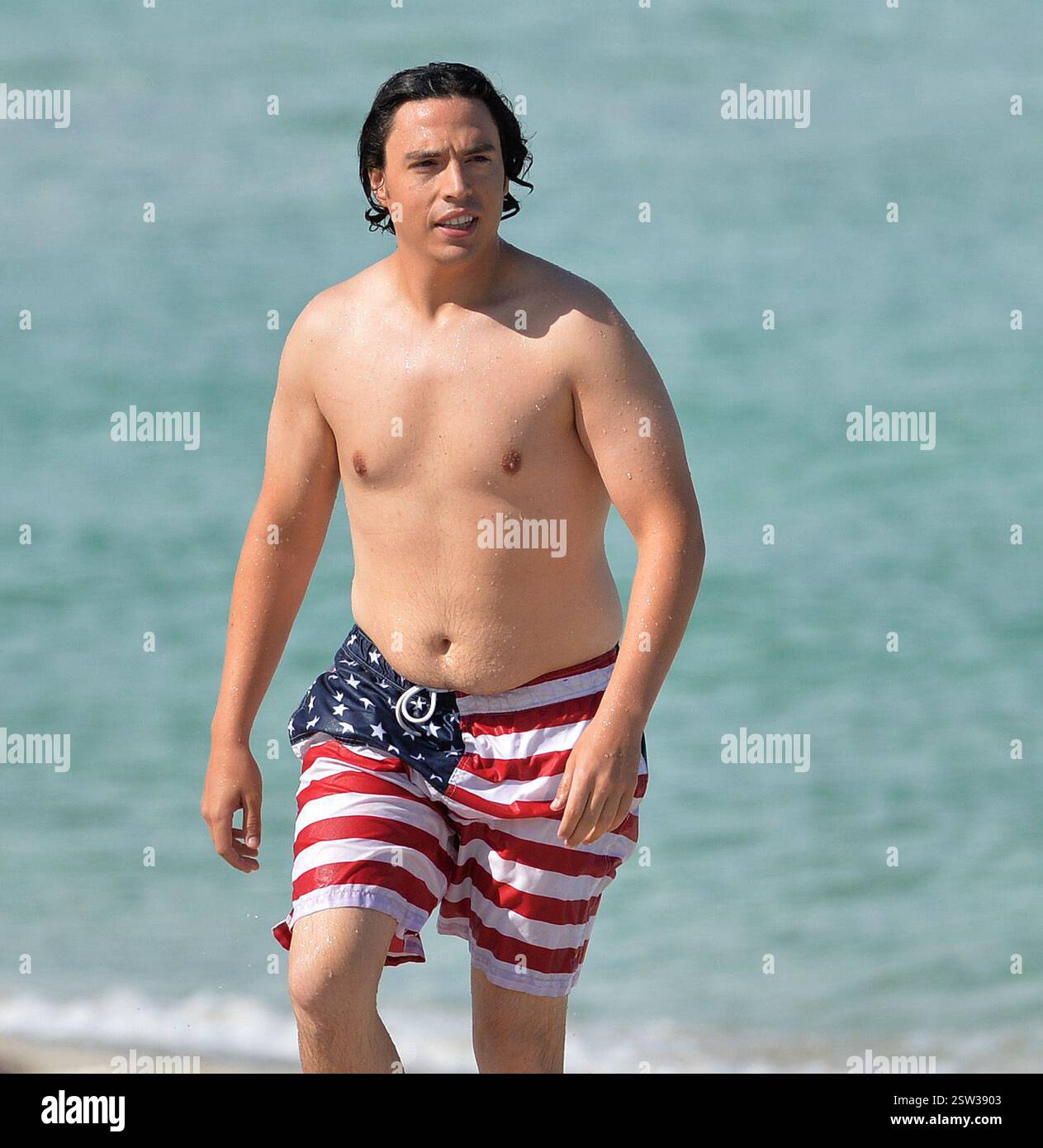 Actor Jon Bass wears 'Stars and Stripes' swimming shorts on the beach ...