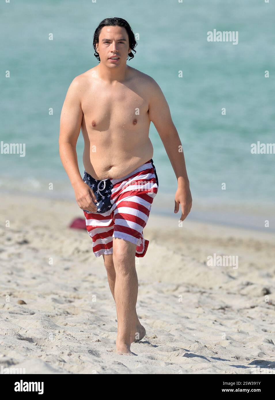 Actor Jon Bass wears 'Stars and Stripes' swimming shorts on the beach ...