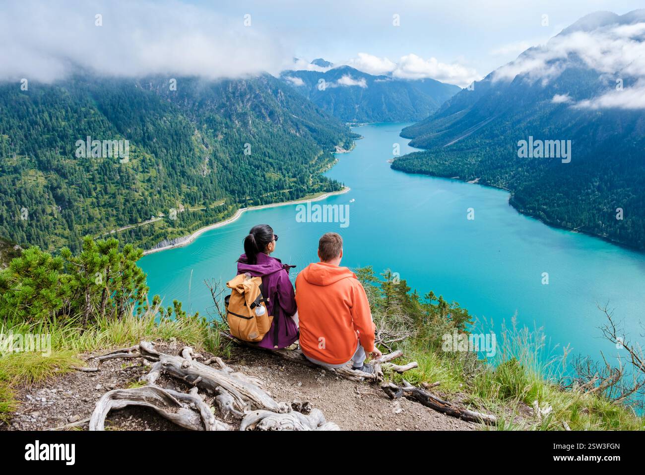 Couple enjoying a breathtaking view of Lake Plansee surrounded by mountains in Austria during ...