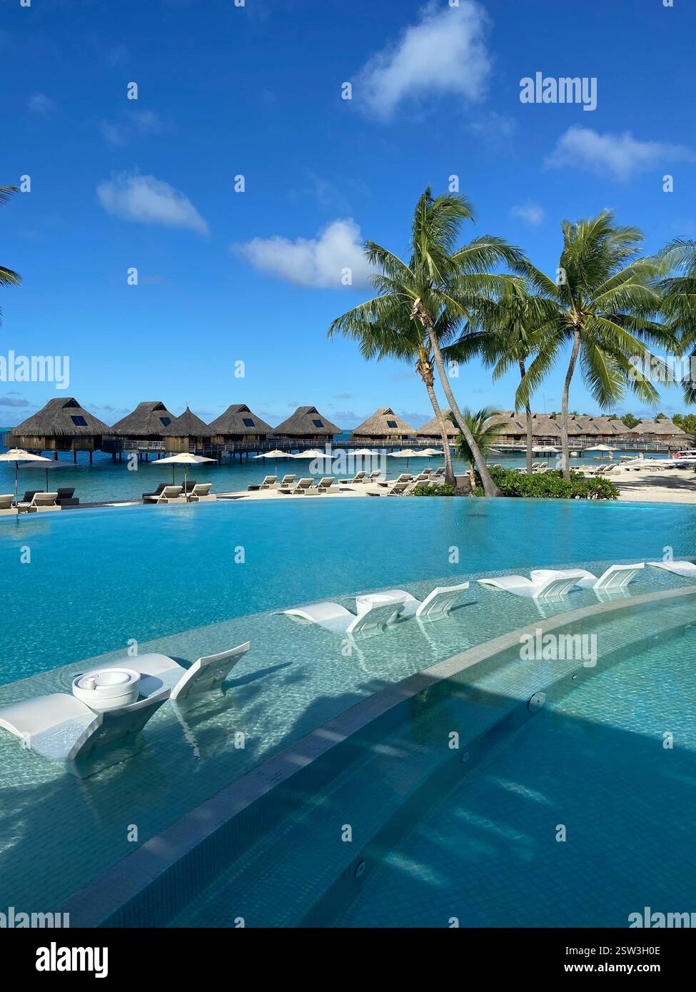 Luxury tropical resort in Bora Bora with an infinity pool and overwater bungalows, surrounded by ...