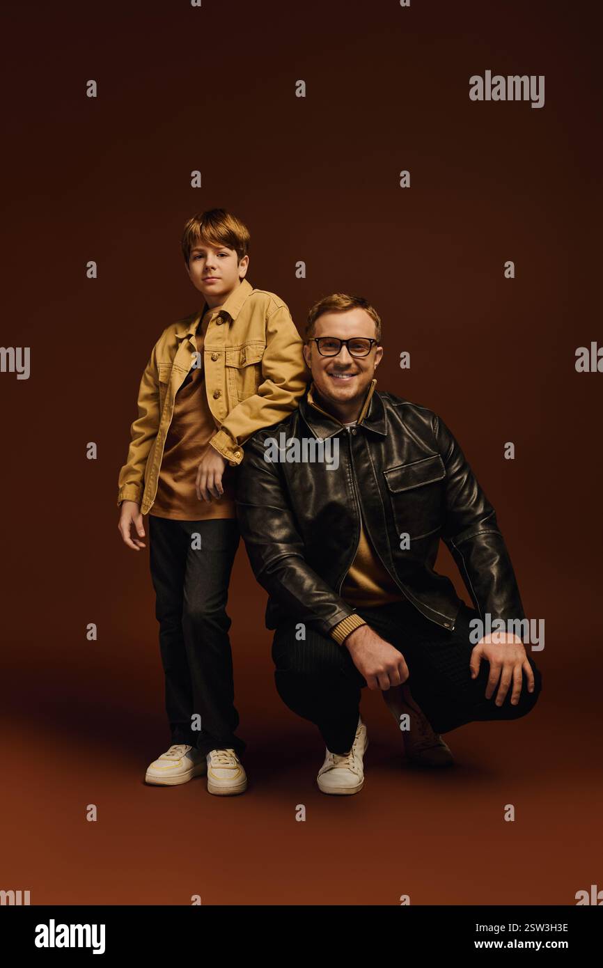 A joyful father and son showcase their fashion in a studio setting ...