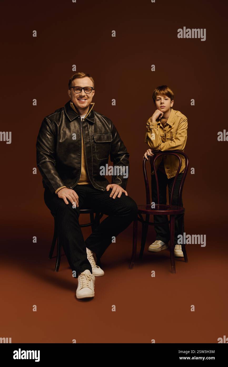 Joyful father and son pose in a casual studio environment, smiling and ...