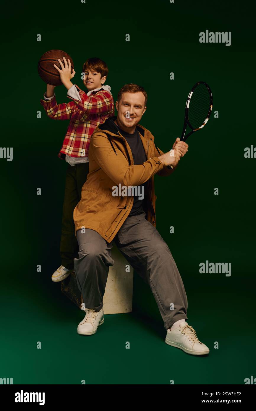 Father and son share a joyful moment while posing playfully in a studio ...