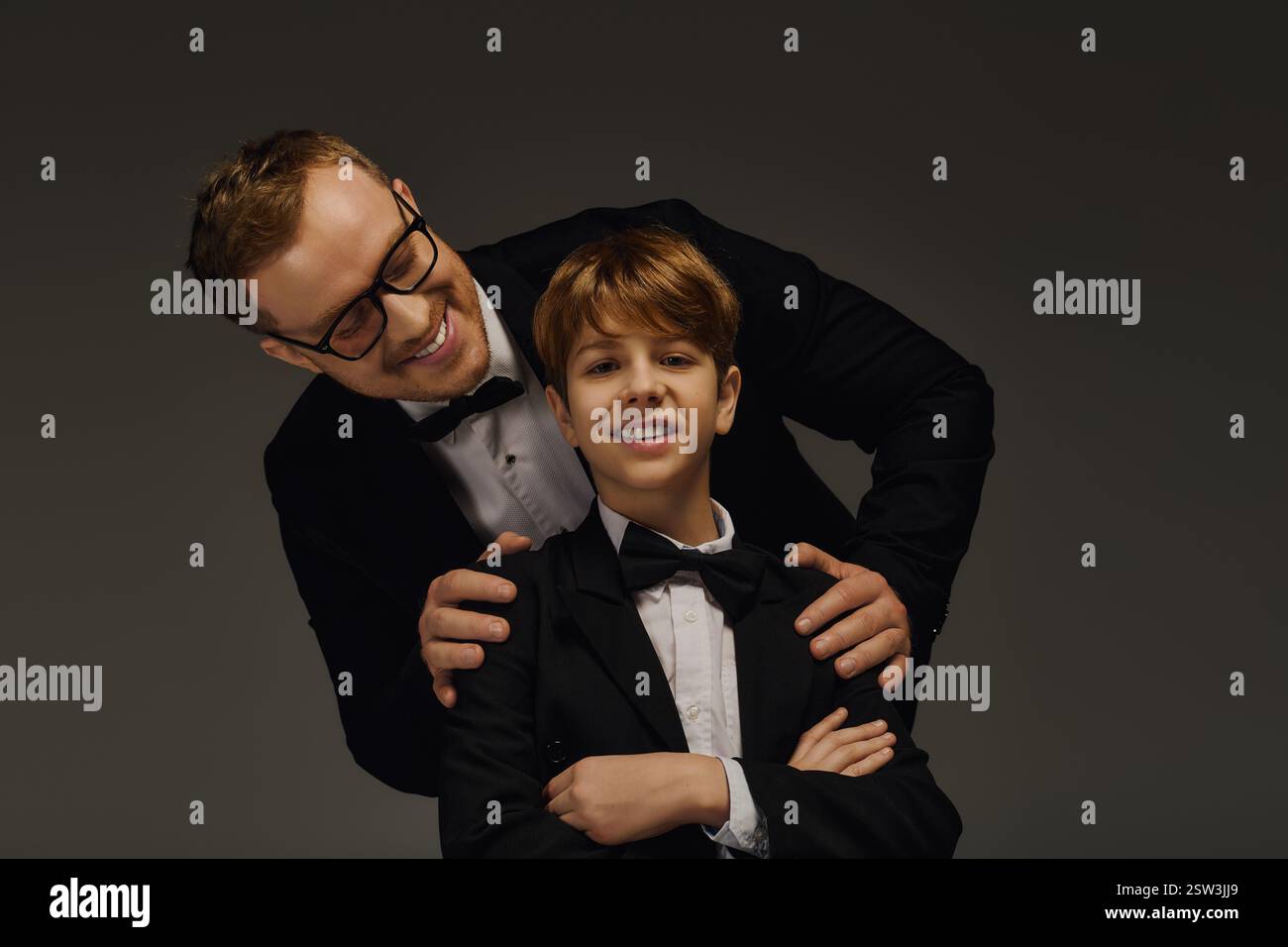 A stylish father and son duo are smiling while dressed in matching ...