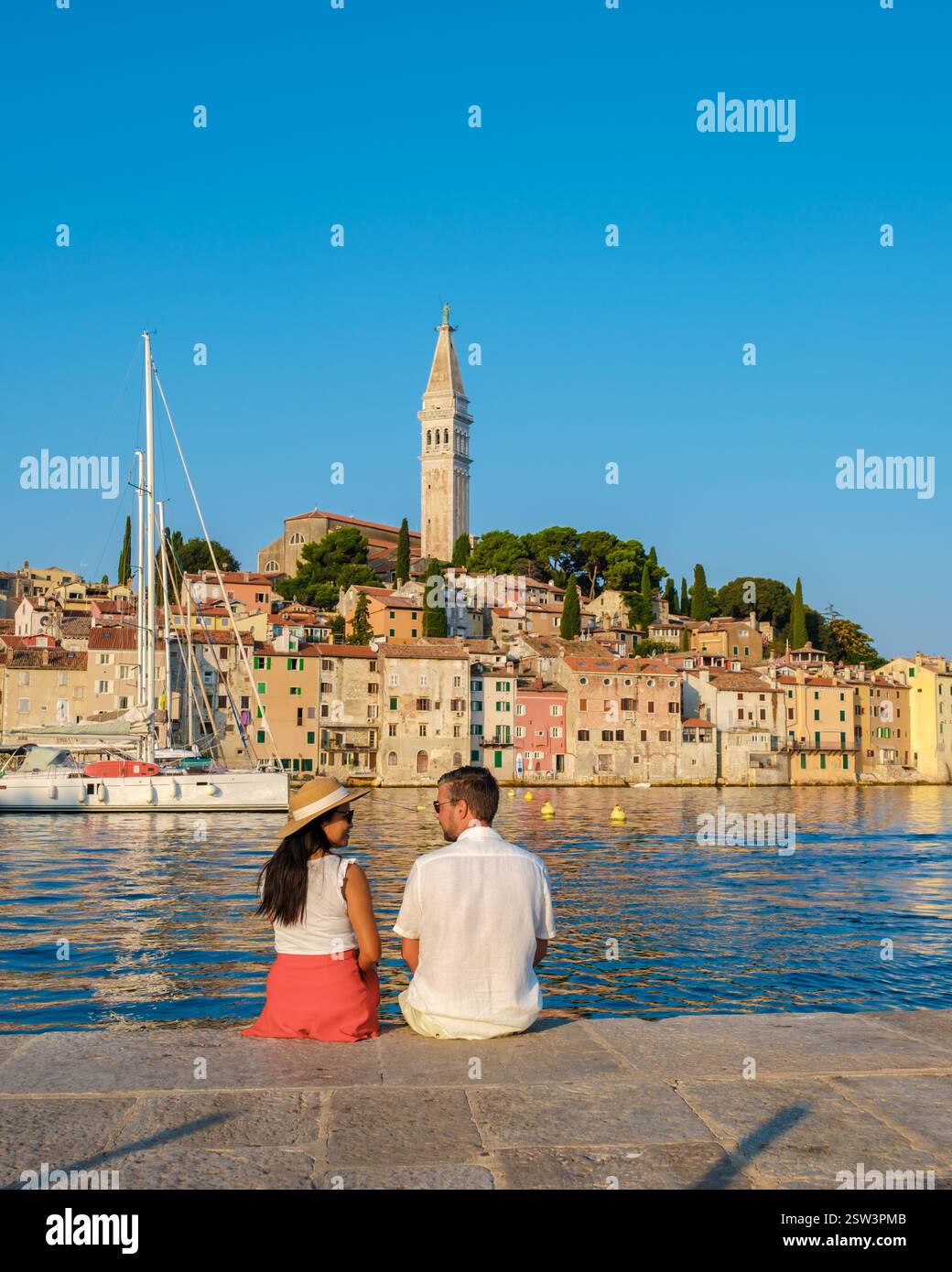 A couple enjoys a tranquil moment by the water in Rovinj, Croatia ...
