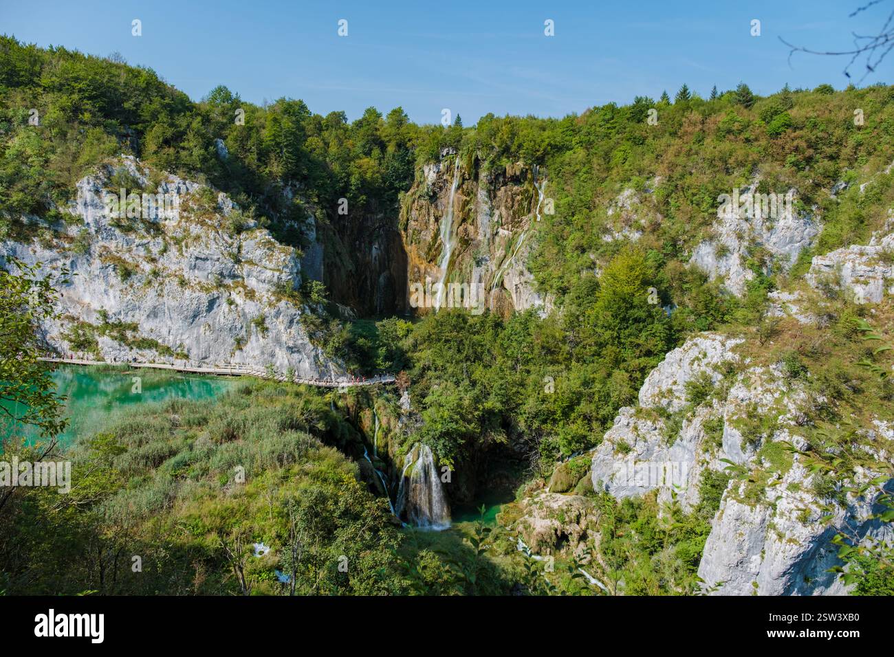 Winding paths lead through vibrant green forests and cascading ...