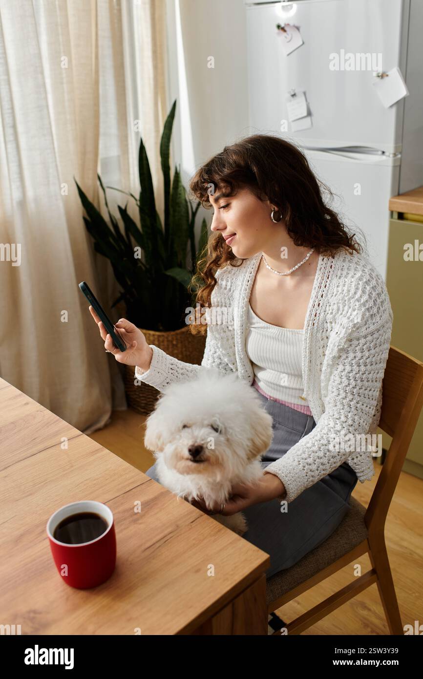 Relaxing at home, a young woman sips coffee and interacts with her ...
