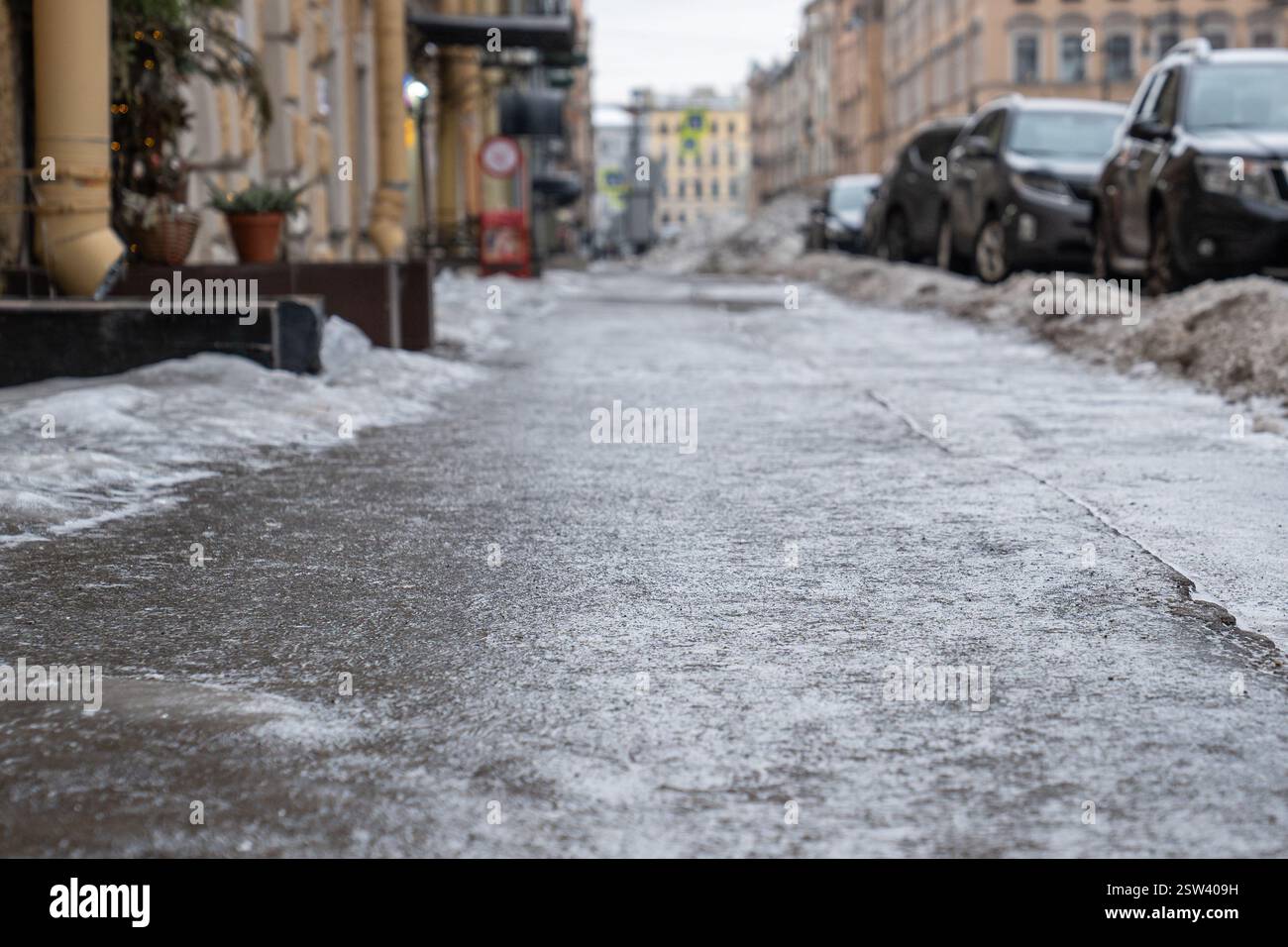 Slippery sidewalk in the city. Pavement covered with slippery ice ...