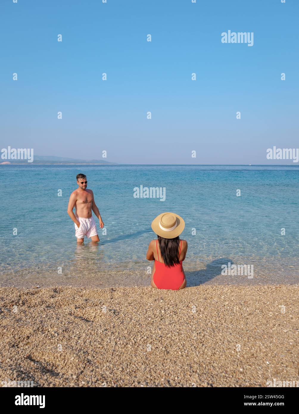 A serene summer afternoon on Brac Island, Croatia with sunbathers and ...
