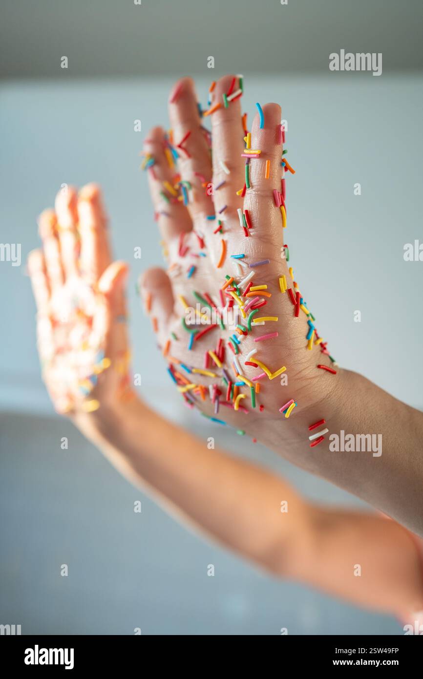 Sticky hands with colorful sprinkles for decorating cupcakes, doughnuts ...