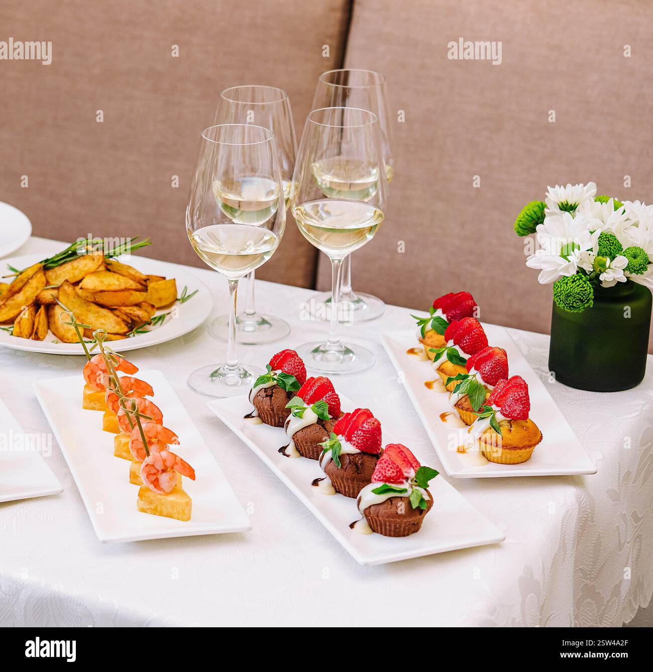 Table with different gourmet snacks for white wine Stock Photo - Alamy