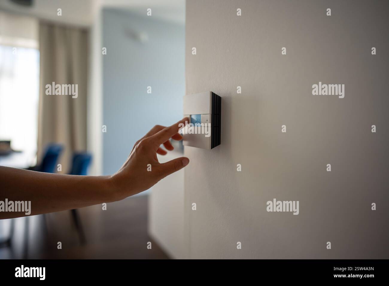 Woman hand adjusts underfloor heating settings in smart home panel for ...