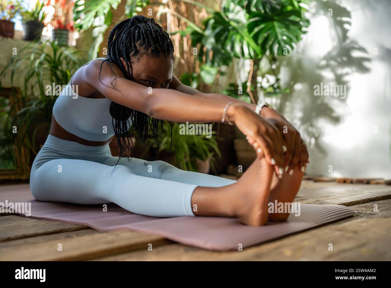 Athletic black woman develops body flexibility after home fitness ...
