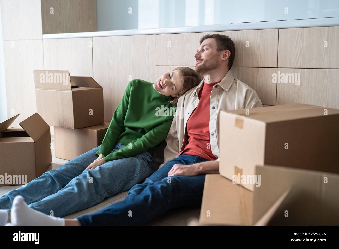 Pleasantly tired couple finished moving things in boxes for move to new ...