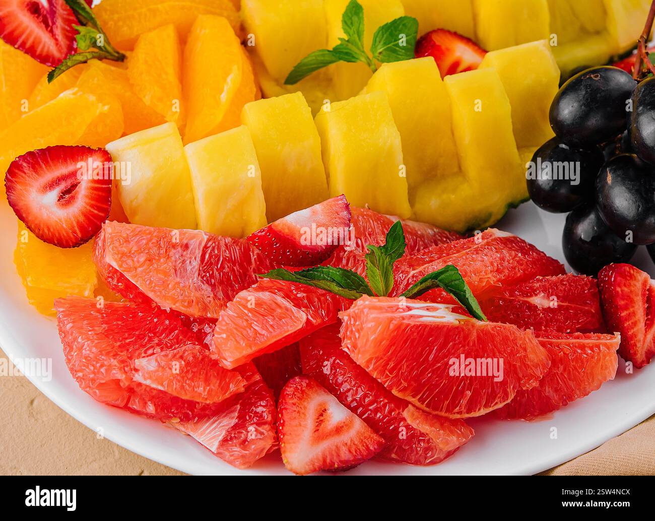 Assorted sliced tropical fruits on plate Stock Photo - Alamy