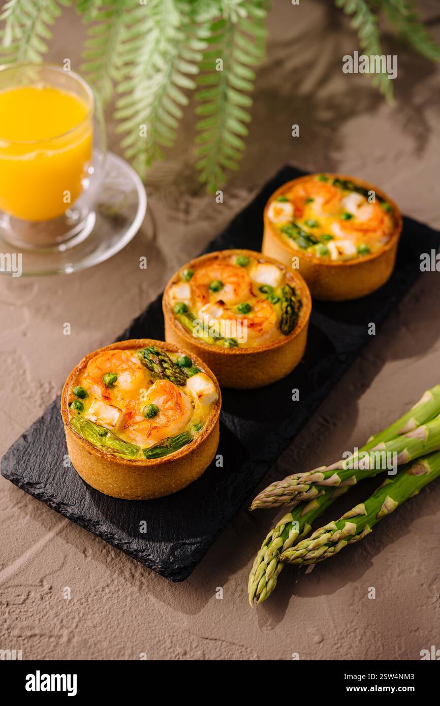 Savory mini quiches with asparagus and orange juice Stock Photo - Alamy