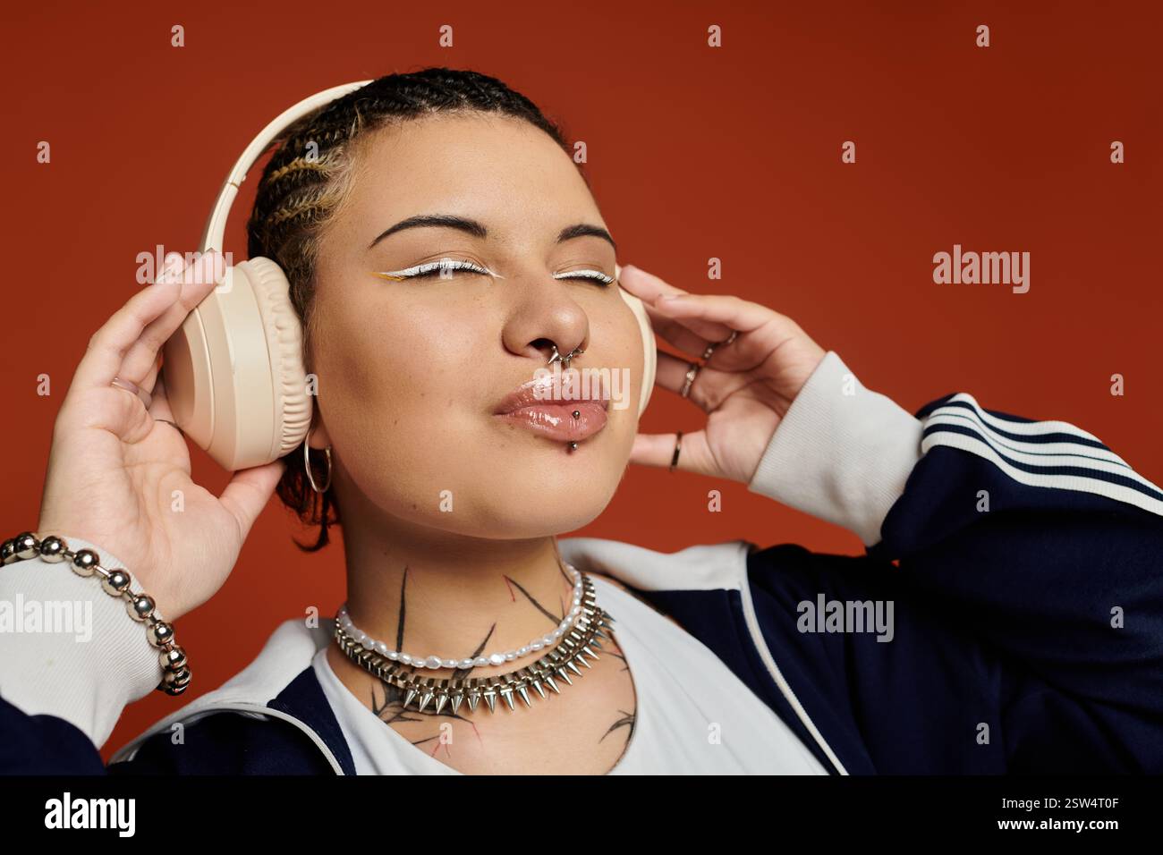 Charming young woman with stylish features loses herself in music while ...