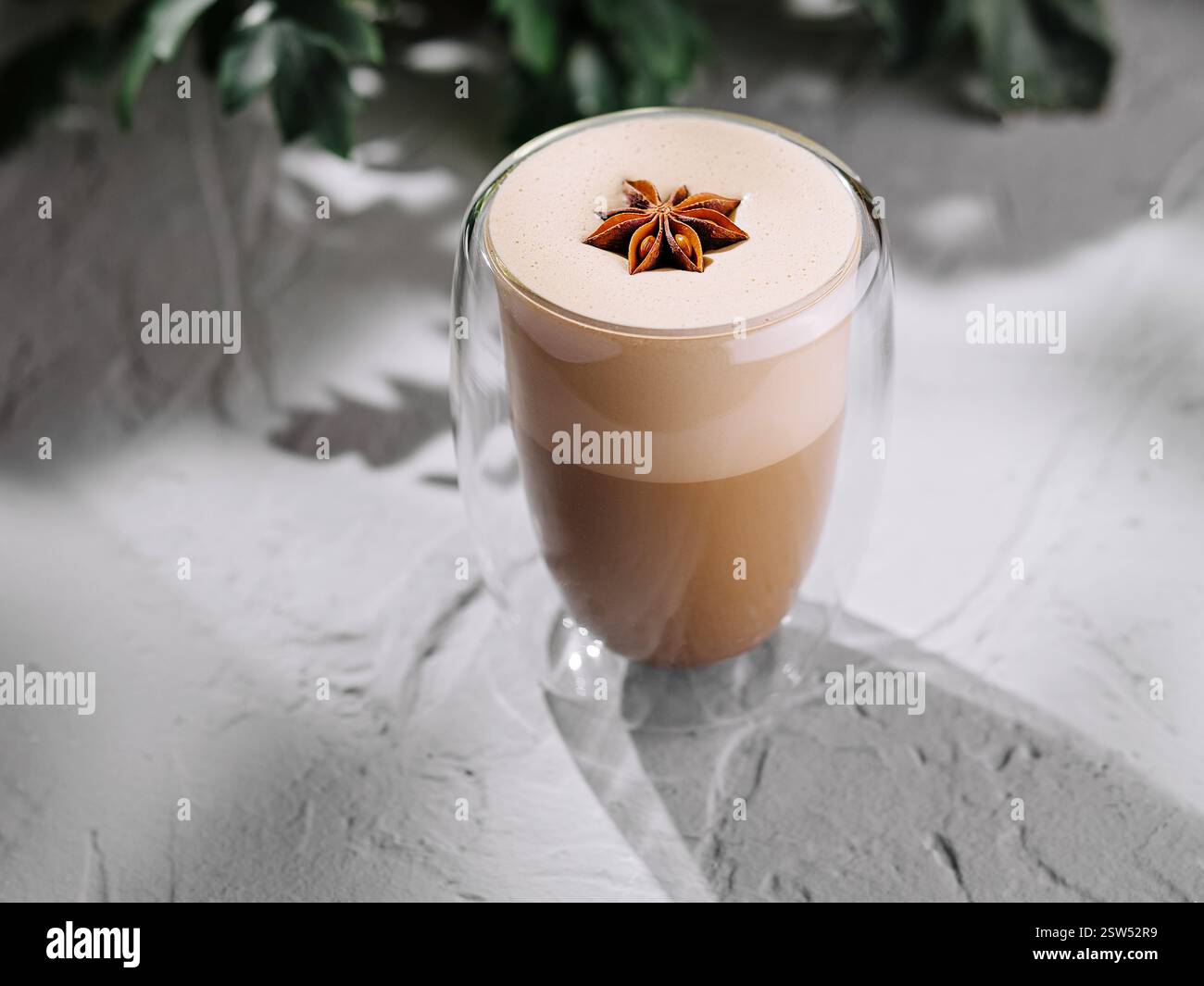 Spiced latte in a transparent glass on textured surface Stock Photo - Alamy