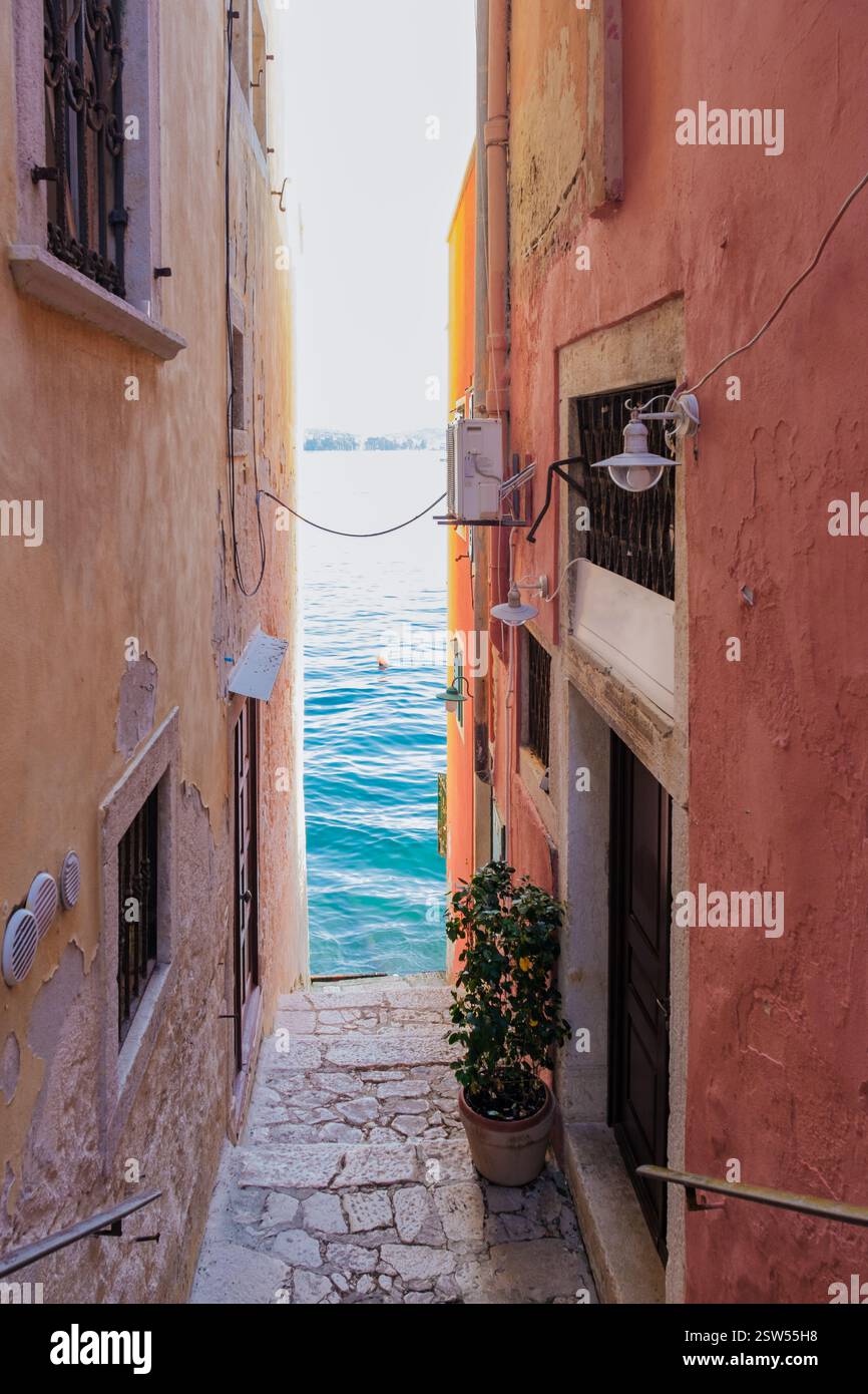 A charming alleyway nestled between pastel-colored buildings opens to ...