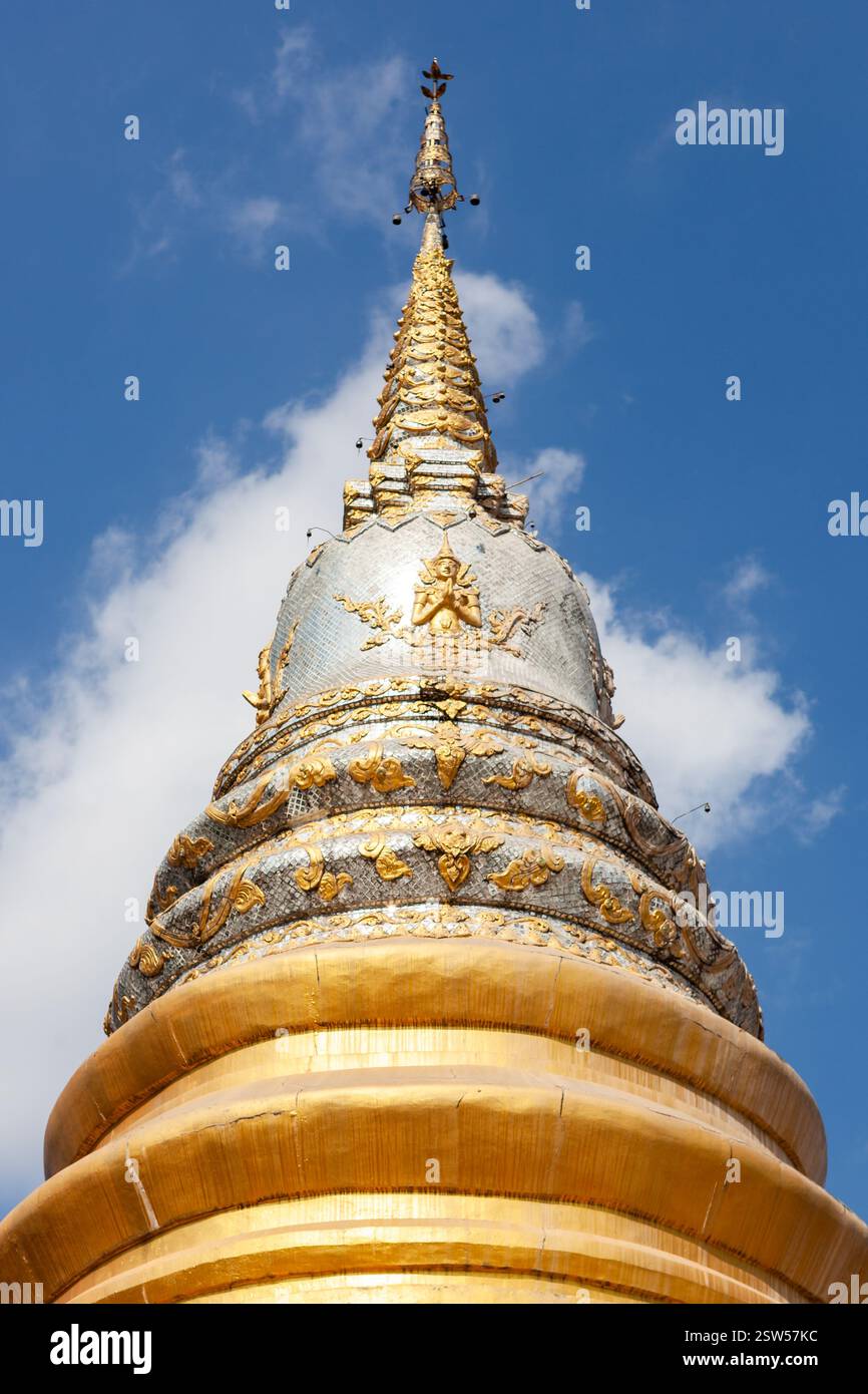 Upper part of Buddhist Stupa on blue sky background at Wat Phrathat ...