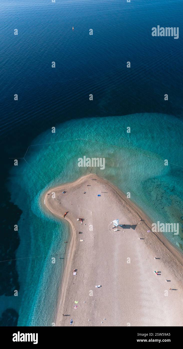 Visitors relax on the sandy beach of Brac Island, Croatia, surrounded ...