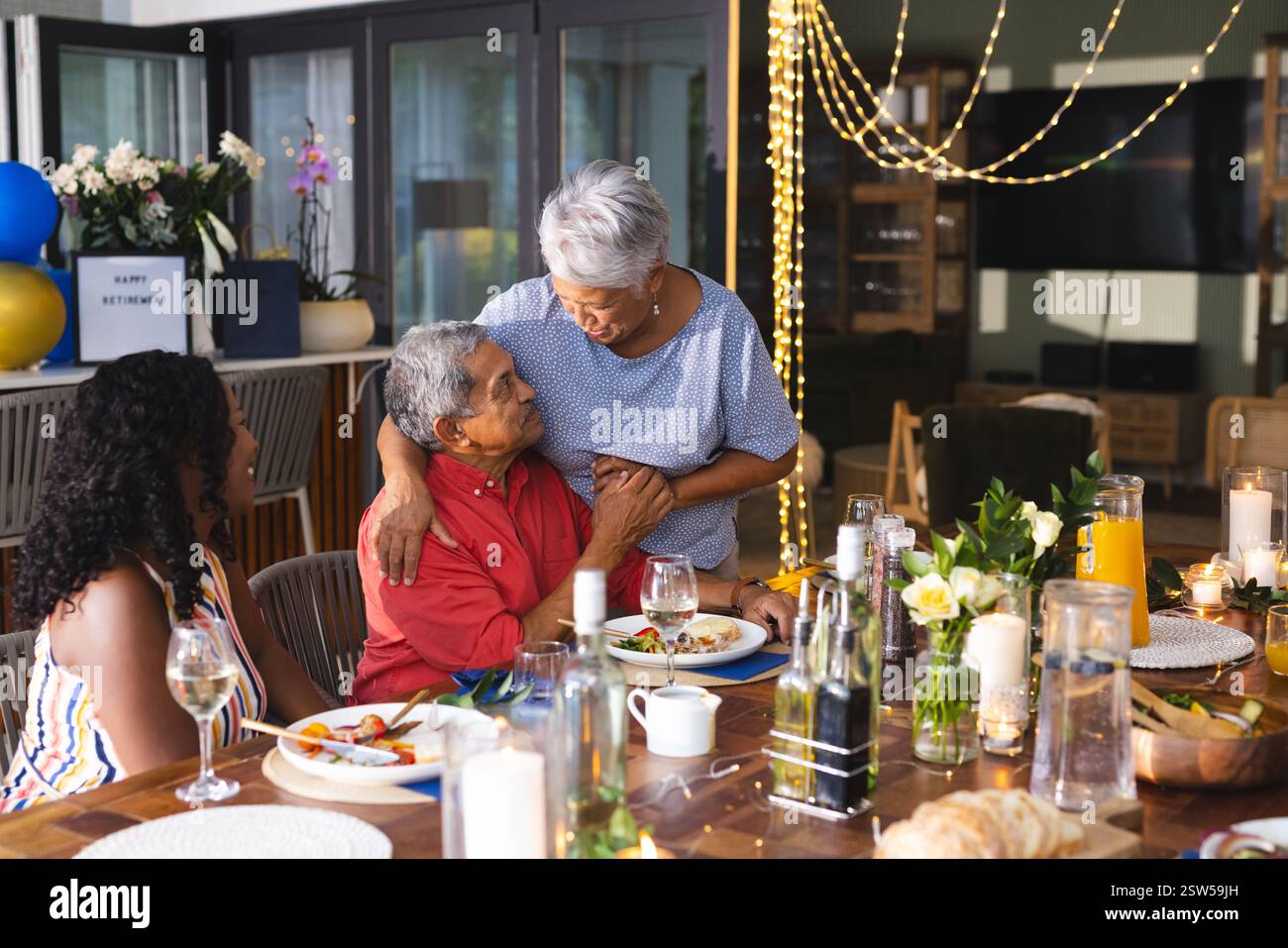 Celebrating retirement, grandparents with multiracial family sharing ...