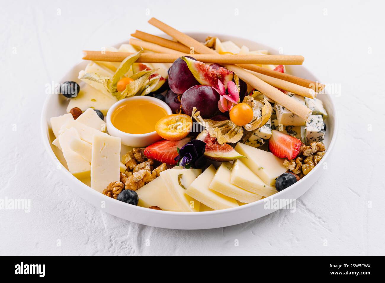 Gourmet cheese platter with fresh fruit and honey Stock Photo - Alamy