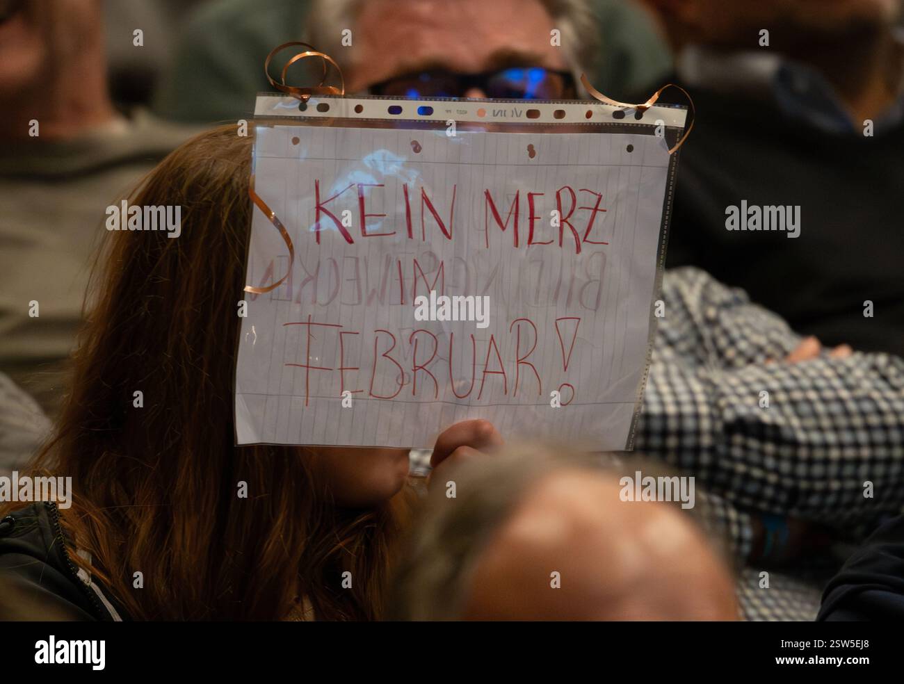 20 February 2025, Hesse, Darmstadt: A woman holds a sign reading "No ...