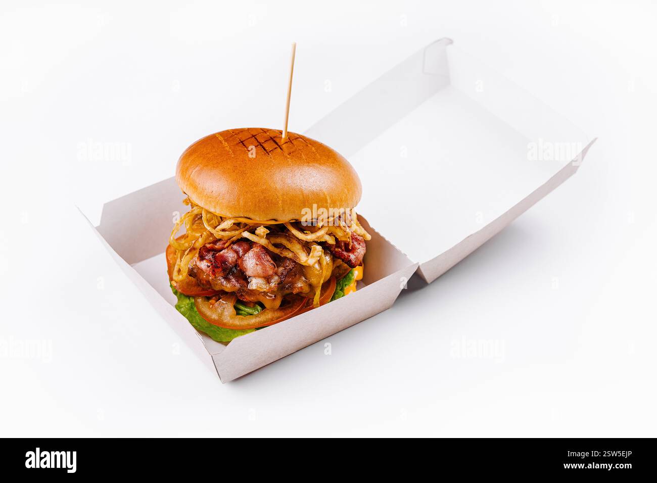 Appetizing cheeseburger with bacon and toppings in an open cardboard ...