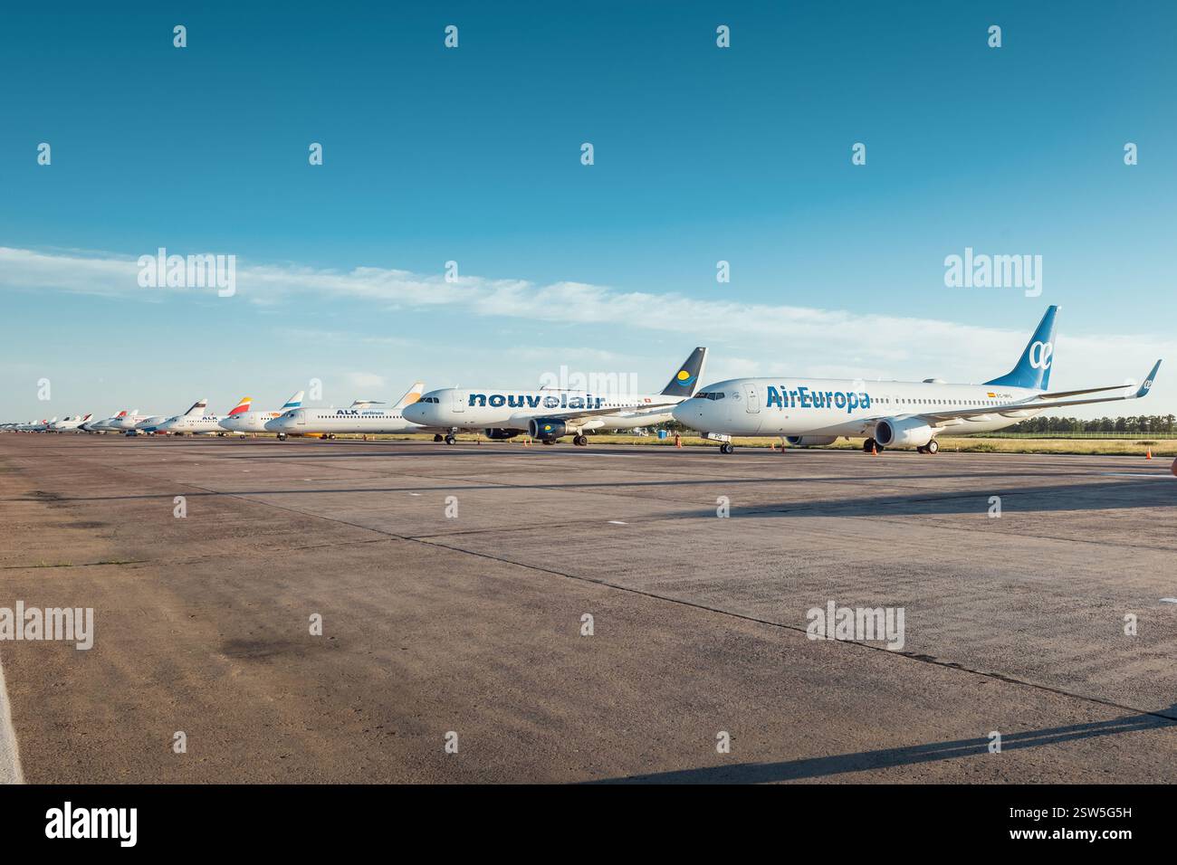 An endless row of airplanes parked in airport on a sunny afternoon ...