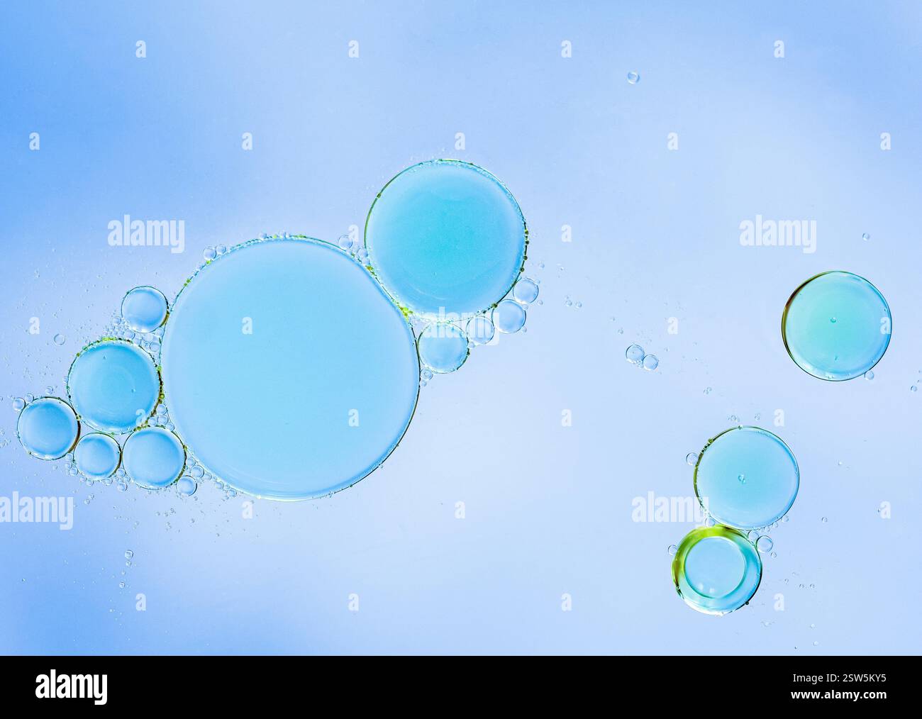 Abstract macro photography of blue oil bubbles floating in water with a ...