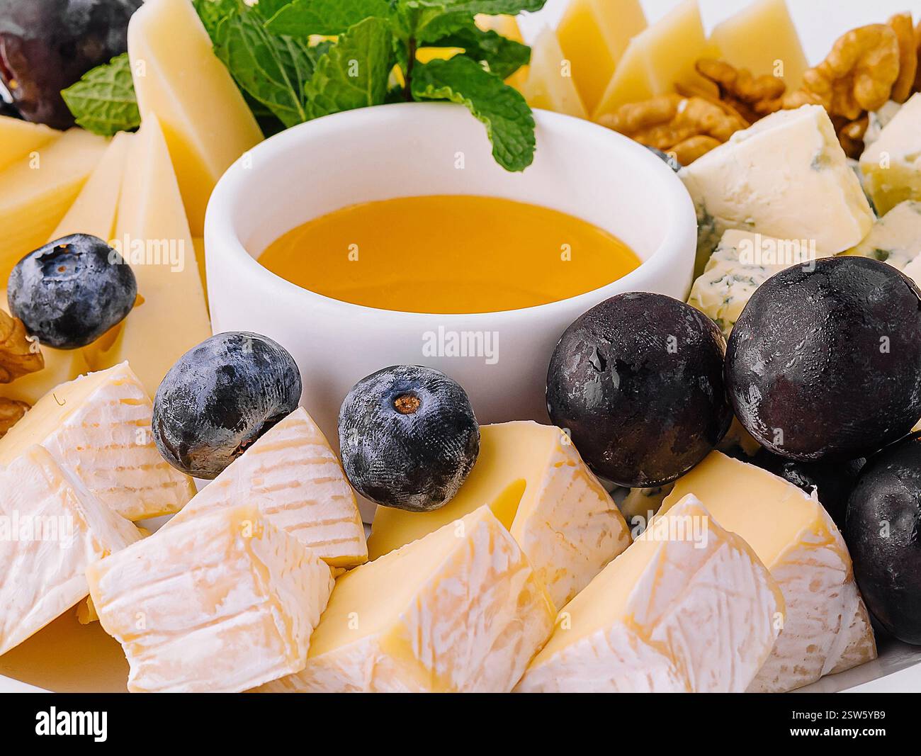 Gourmet cheese platter with honey and fruits Stock Photo - Alamy
